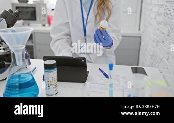 Young woman scientist examining a medication bottle in a modern ...