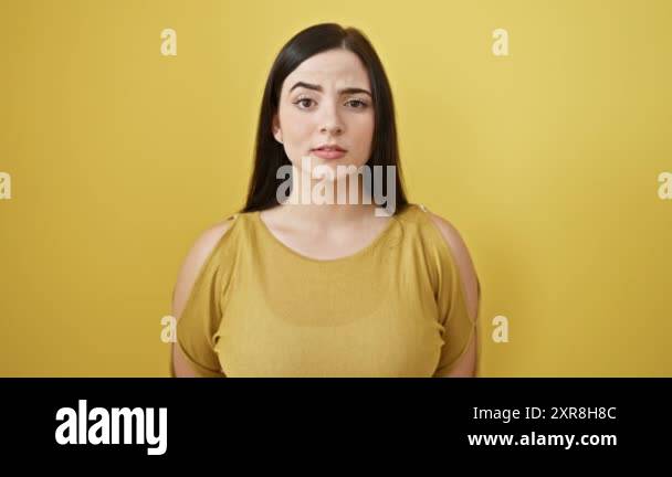 Frowning, upset young hispanic woman, a skeptic doubter with negative emotion, standing ...