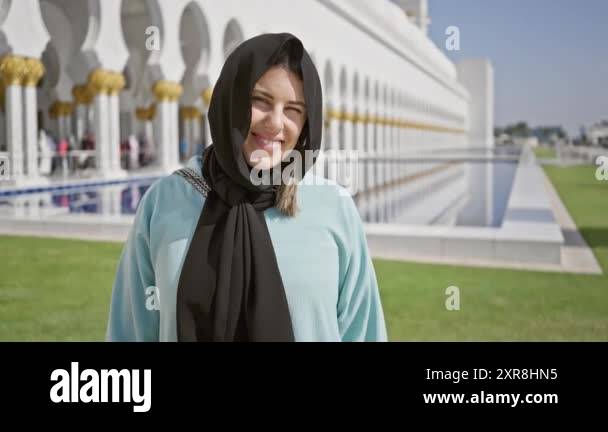 A smiling young woman in a hijab at the sheikh zayed grand mosque in ...