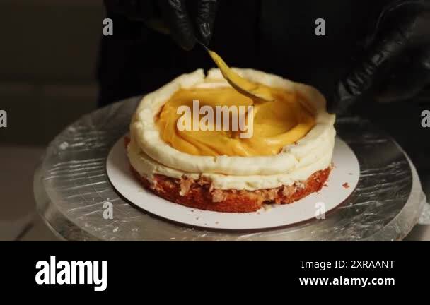 A woman pastry chef is preparing a mango passion fruit cake.The pastry ...