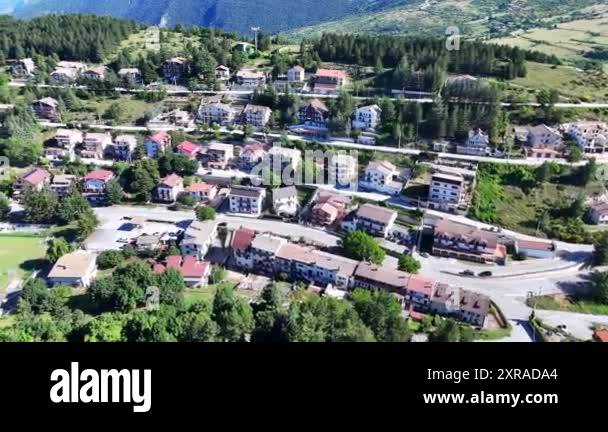 A picturesque mountain village unfolds under the warm sunlight ...