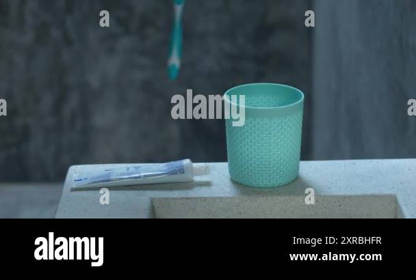 Hand places toothbrush back in cup marking end of dental hygiene ...