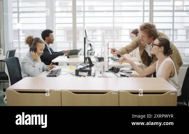 In a collaborative office setting, employees work as a team to engage ...