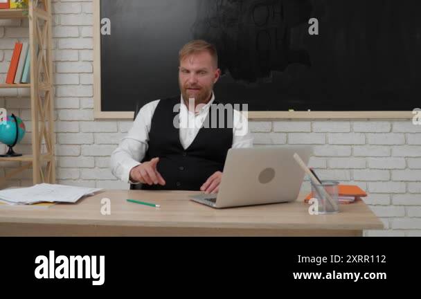 School teacher speaking to young people in class. Man college teacher ...