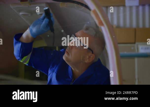 Engineer working on aircraft cockpit with technical schematics ...