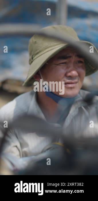 slow motion Vietnamese mechanic with a big hat working repairing the ...