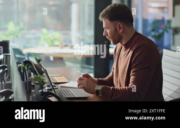 Busy employee focusing on laptop task at modern corporate interior ...