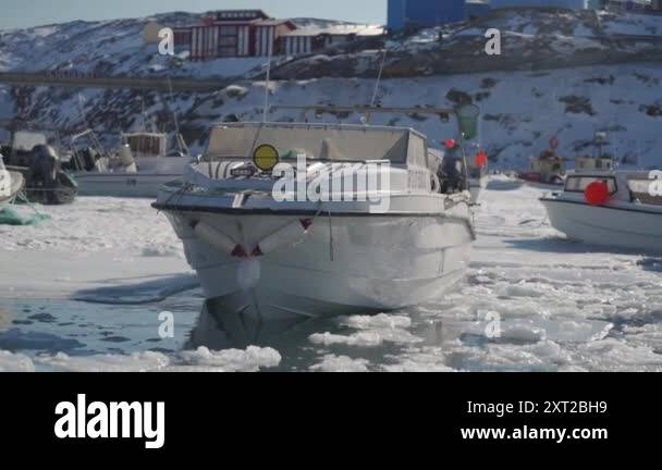 A picturesque winter scene of boats anchored in an icy harbor ...