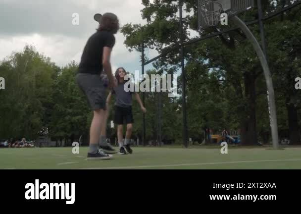 Two brothers practice basketball shots, enjoying carefree playtime. A ...