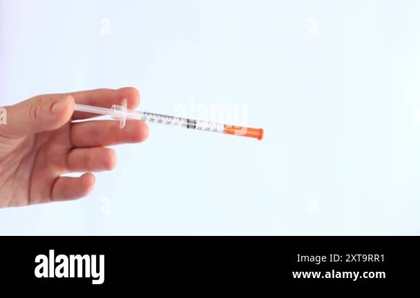 Insulin syringe. A woman's hand holds a syringe on a white background ...