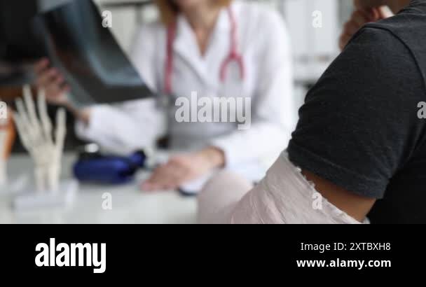 Doctor examines x-ray of patient with broken arm. Traumatologist and ...