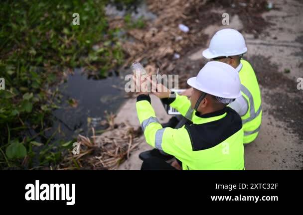 Environmental engineers work at water source to check for contaminants in water sources and ...