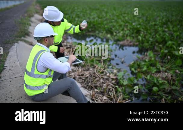 Environmental engineers work at water source to check for contaminants in water sources and ...