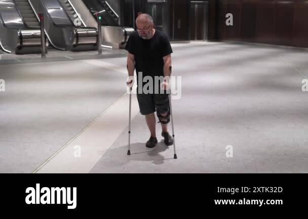 Mature man with bondage, medical splint, knee brace on the leg going to ...