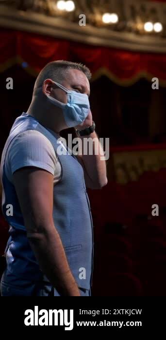 Actor in medical mask on theatre scene. Man rehearsing on stage and ...