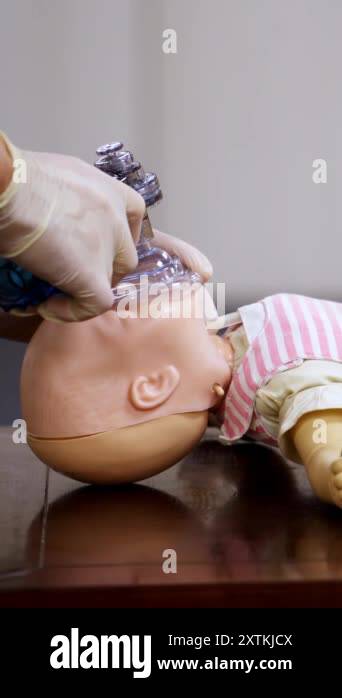 Demonstration of cpr on a baby model. Instructor in medical gloves ...