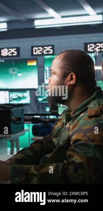 Vertical video Air force officer and colleague performing tactical level surveillance in command ...