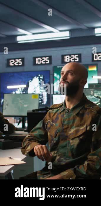 Vertical video Military agent using augmented reality tech in control room, analyzing aerial ...