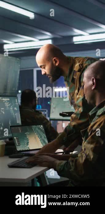 Vertical video Military soldier in mission control center, overseeing national safety operations ...