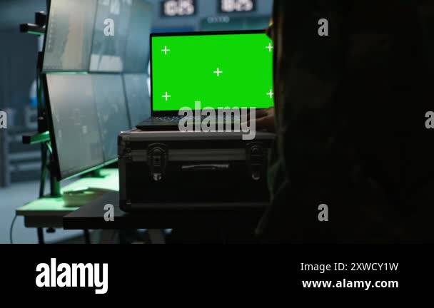 Army specialist working in war room operating surveillance tech, evaluating target data on ...