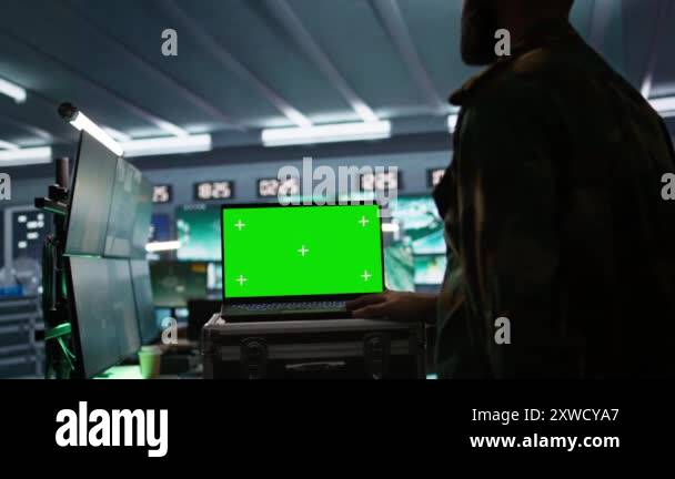 Army specialist working in war room operating surveillance tech, evaluating target data on ...