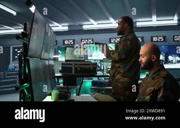 Military soldier wearing camo uniform in mission control center ...