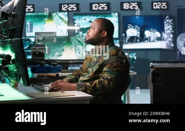 Military agent working in control room, analyzing aerial reconnaissance ...