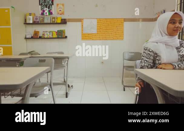 A classroom filled with students sitting at desks, facing the front ...