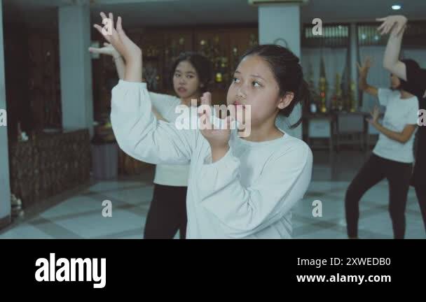 Three women practicing traditional dance moves indoors, focusing on ...