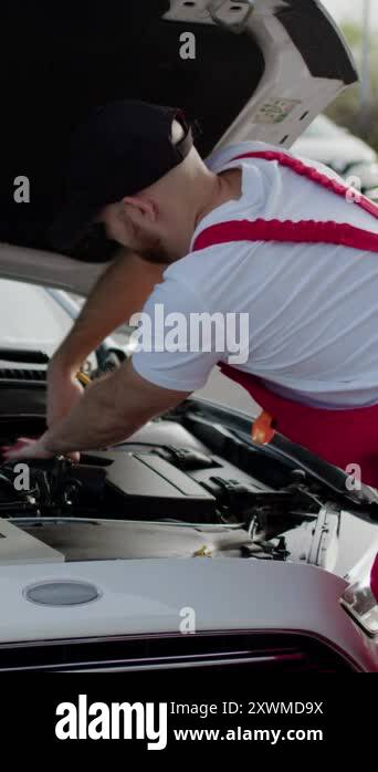 Auto mechanic diligently repairs the defective car brought to the auto ...