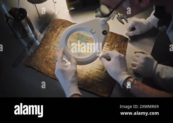 Two scientists examine ancient Egyptian papyrus together in ...