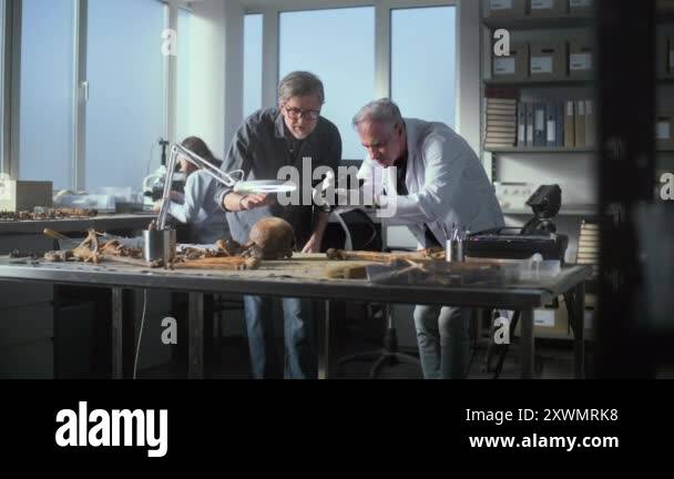 Senior paleoanthropologist takes photo of fossil remains of prehistoric ...