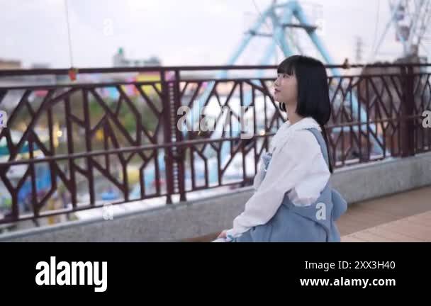 A young Taiwanese woman in her twenties spends time sitting on a pink character themed bench at ...