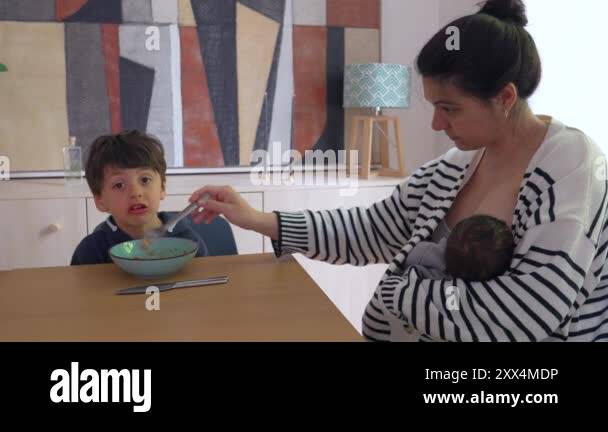 Child expressing reluctance to eat food offered by mother who is ...