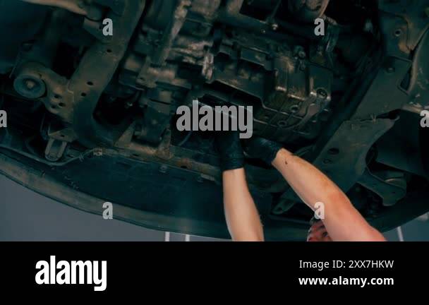 close up an auto mechanic at a service station checks a car being ...