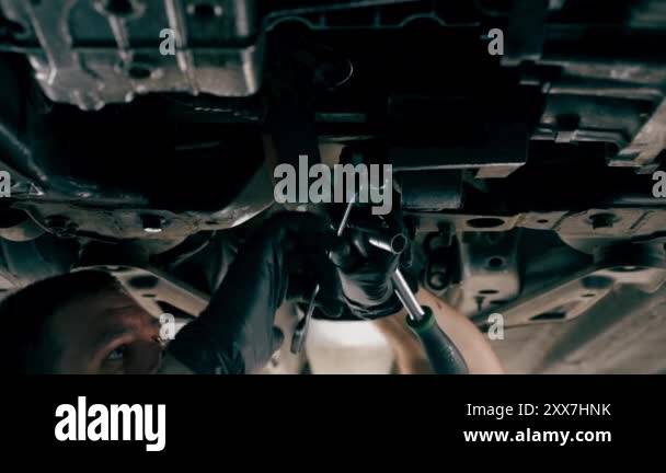 close up an auto mechanic at a service station checks a car being ...