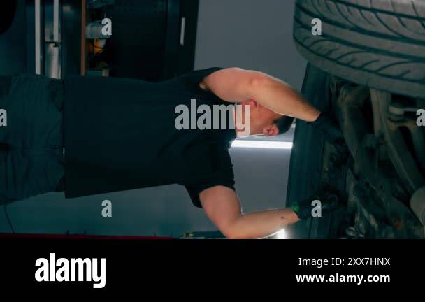 vertical video an auto mechanic at a service station checks a car being ...