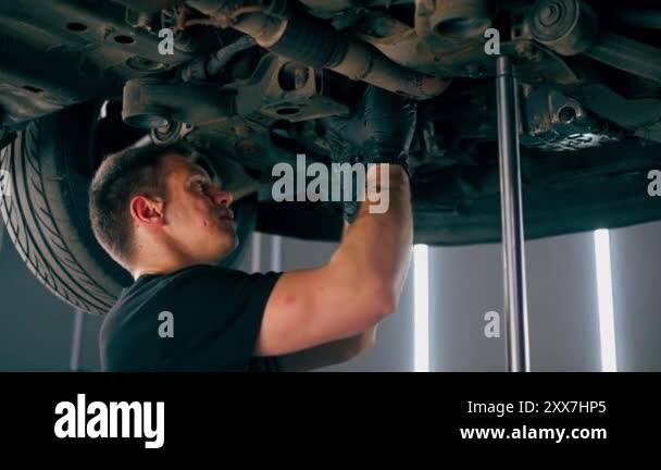 close up an auto mechanic at a service station checks a car being ...