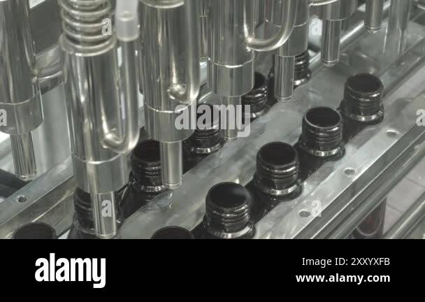 Bottles filling automation machine in modern factory. Technology ...