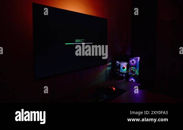 Dark Room with Computer Setup, Monitor Displaying Green Loading Text ...
