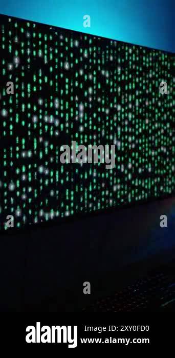 Vertical video. Dark Room with Computer Setup, Large Monitor Displaying ...