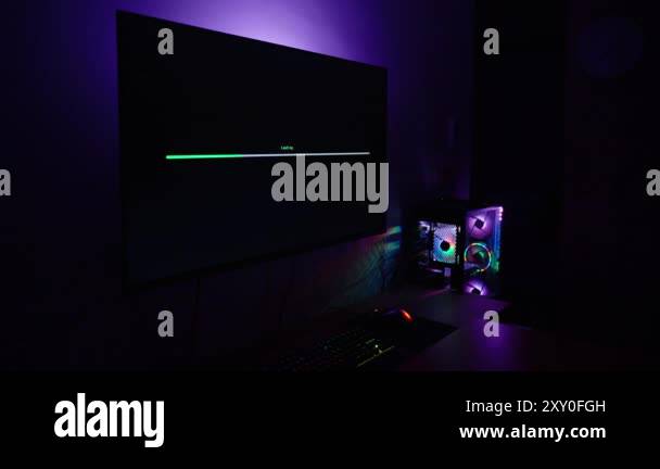 Dark Room With Computer Setup Monitor Displaying Loading Bar And