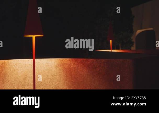 A serene nighttime scene featuring modern outdoor lamps casting warm ...