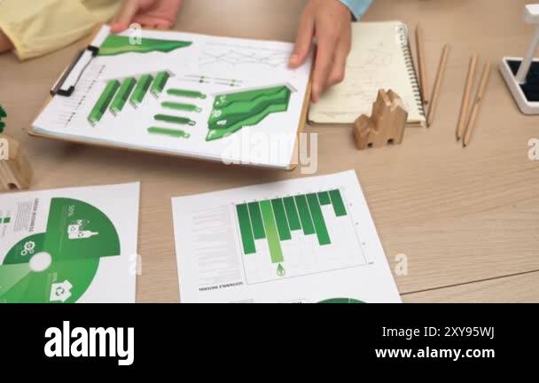 Business team consulting and analyzing green power graph usage for ...