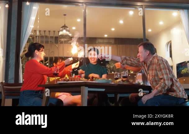 Happy family holding glowing sparkler in holiday celebration party at ...