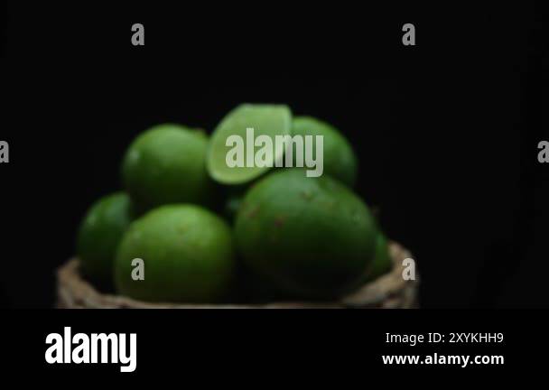 Slices of lime are meticulously arranged in a pile, set against a black ...