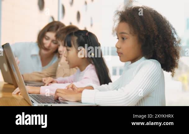 African girl play laptop with diverse friend learning prompt at STEM technology class ...