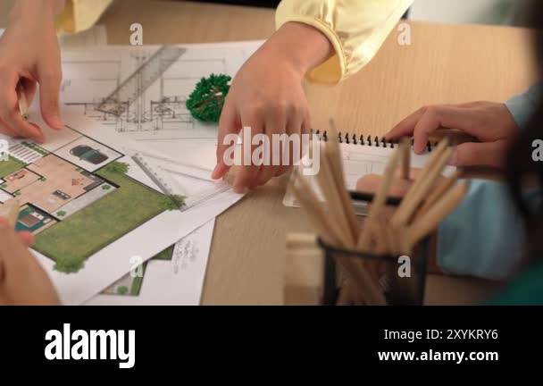 Architects using measurement tool and pencil tracing in building ...