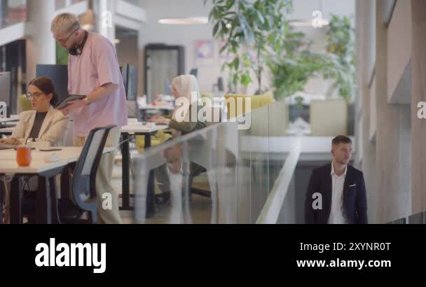 A director arrives at a large, modern office, where he joins his ...