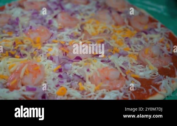 shows the process of adding cheese on an artisanal pizza in preparation ...